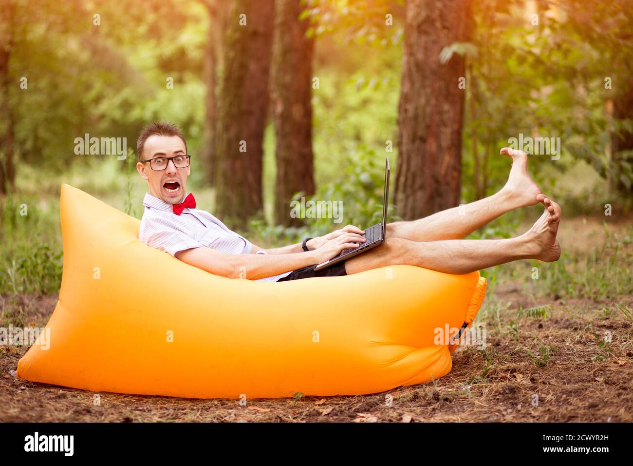 Young freelancer man with shocked face in shirt, red bow tie and ...
