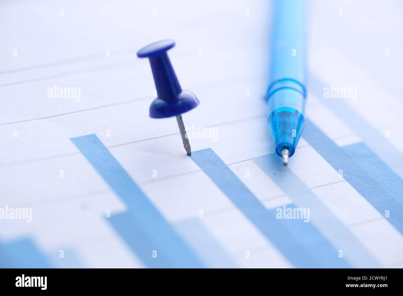 Close up of bar charts with push pin and pen on table Stock Photo - Alamy