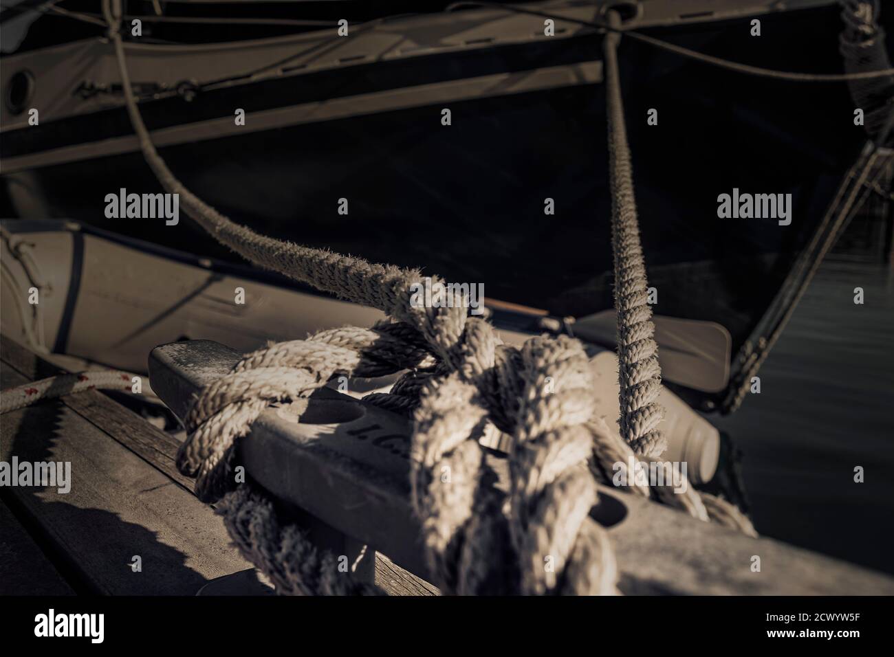 Close up of the mooring cleat with a boat rope tied around it ...