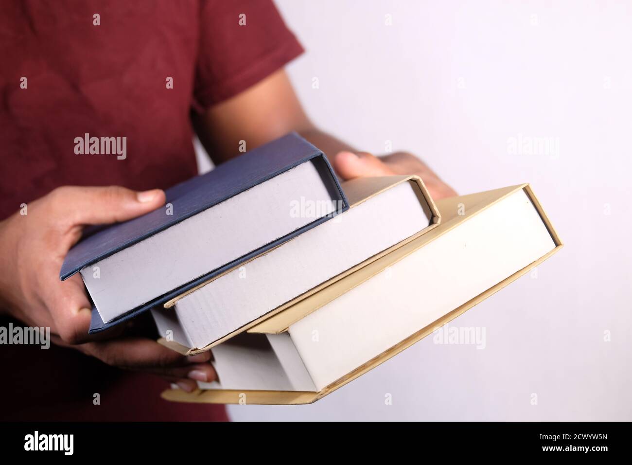 hand holding stack of books on white background Stock Photo - Alamy