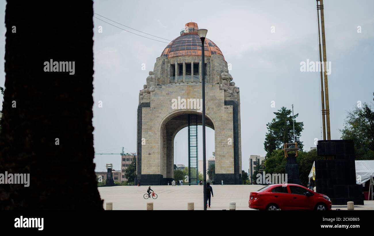 Monument to the Revolution Across the Street with a Red Car Passing By ...