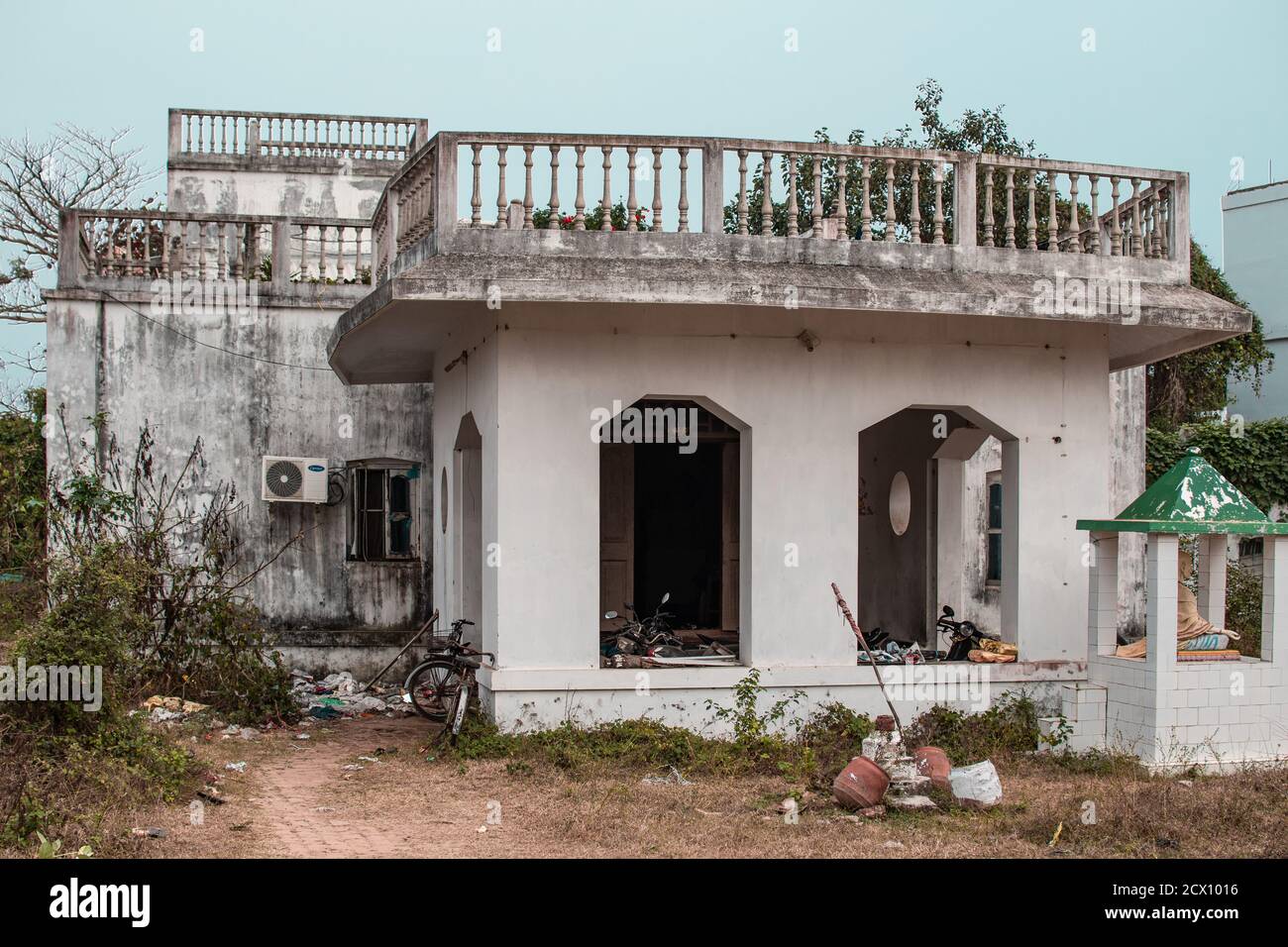 View of an old destroyed and abandoned white residential house in Puri ...