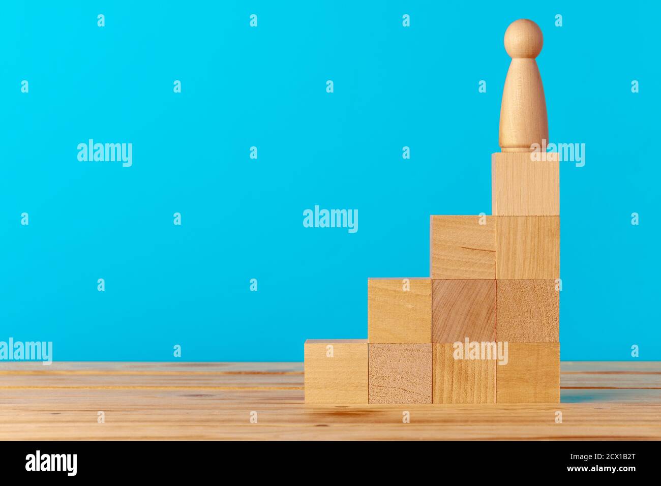 Stacked wooden blocks on wooden desk against blue background Stock ...