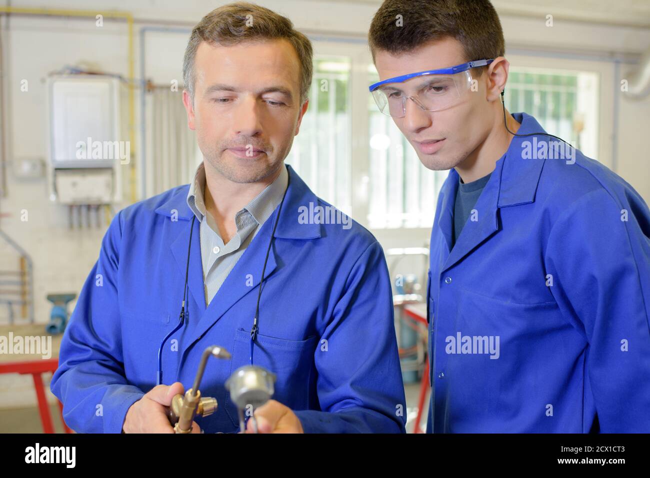 Tutor and apprentice with gas burner Stock Photo - Alamy
