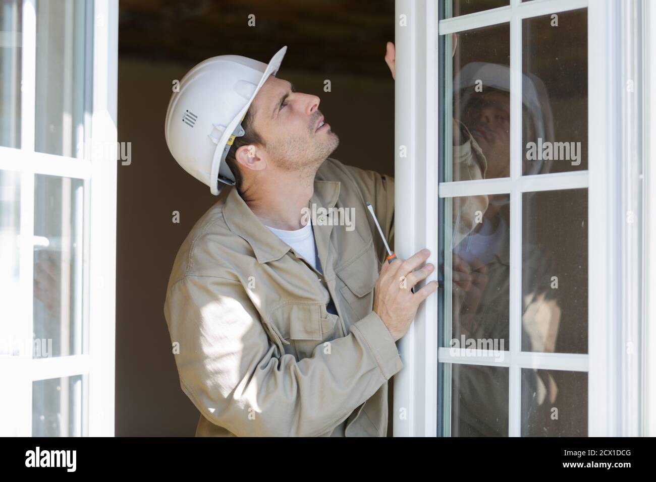 a male worker is fixing a window Stock Photo - Alamy