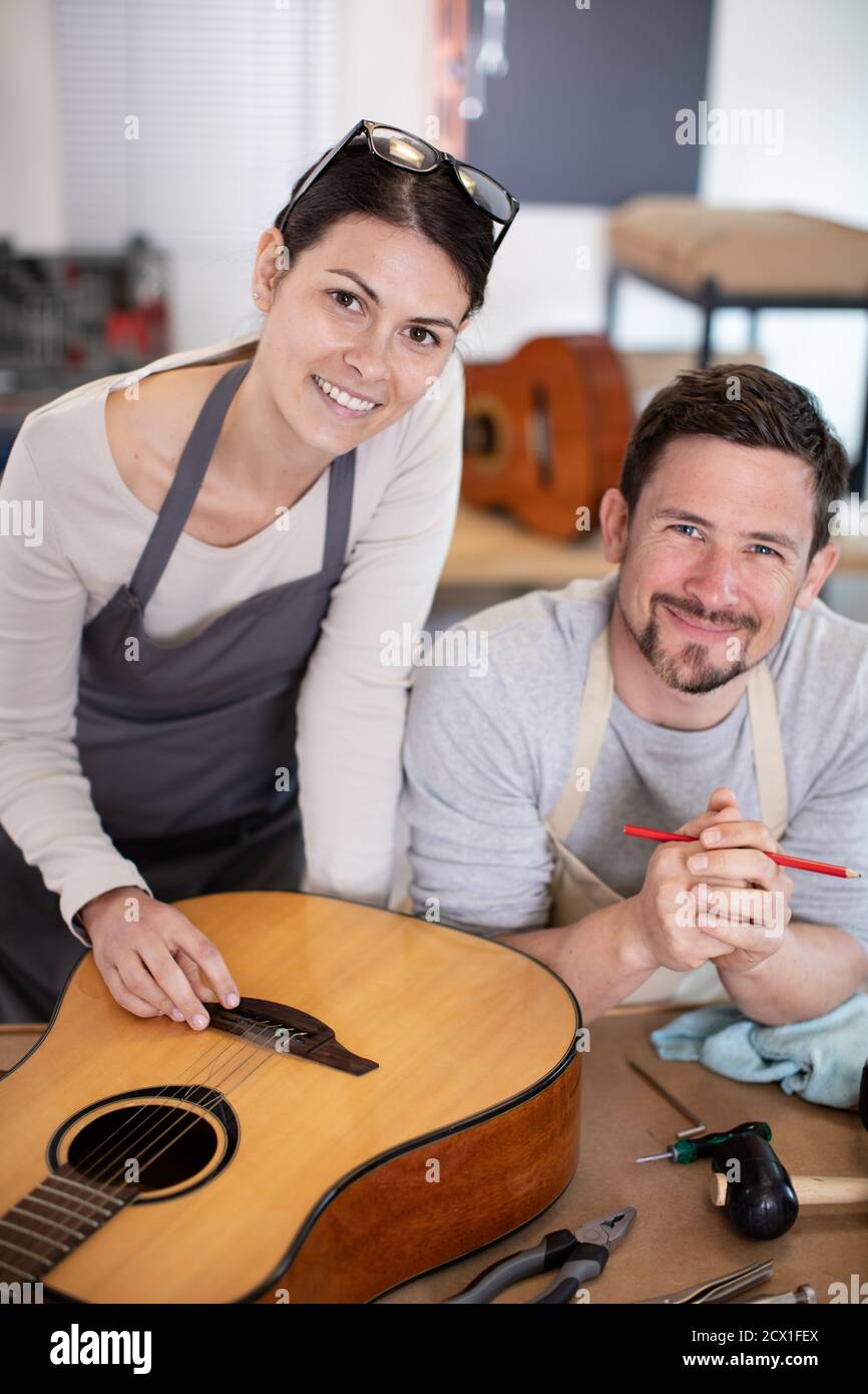 luthier and guitar maker apprentice repair guitar in teamwork Stock ...
