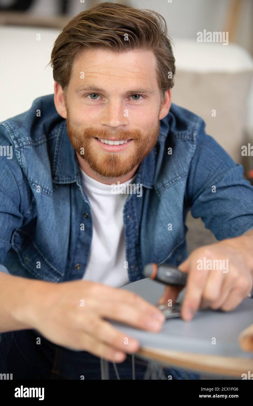 young man repair something inside kitchen cabinet Stock Photo - Alamy
