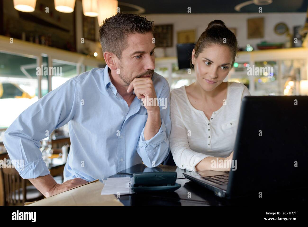 owner of restaurant explaining changes in online menu to waitress Stock ...
