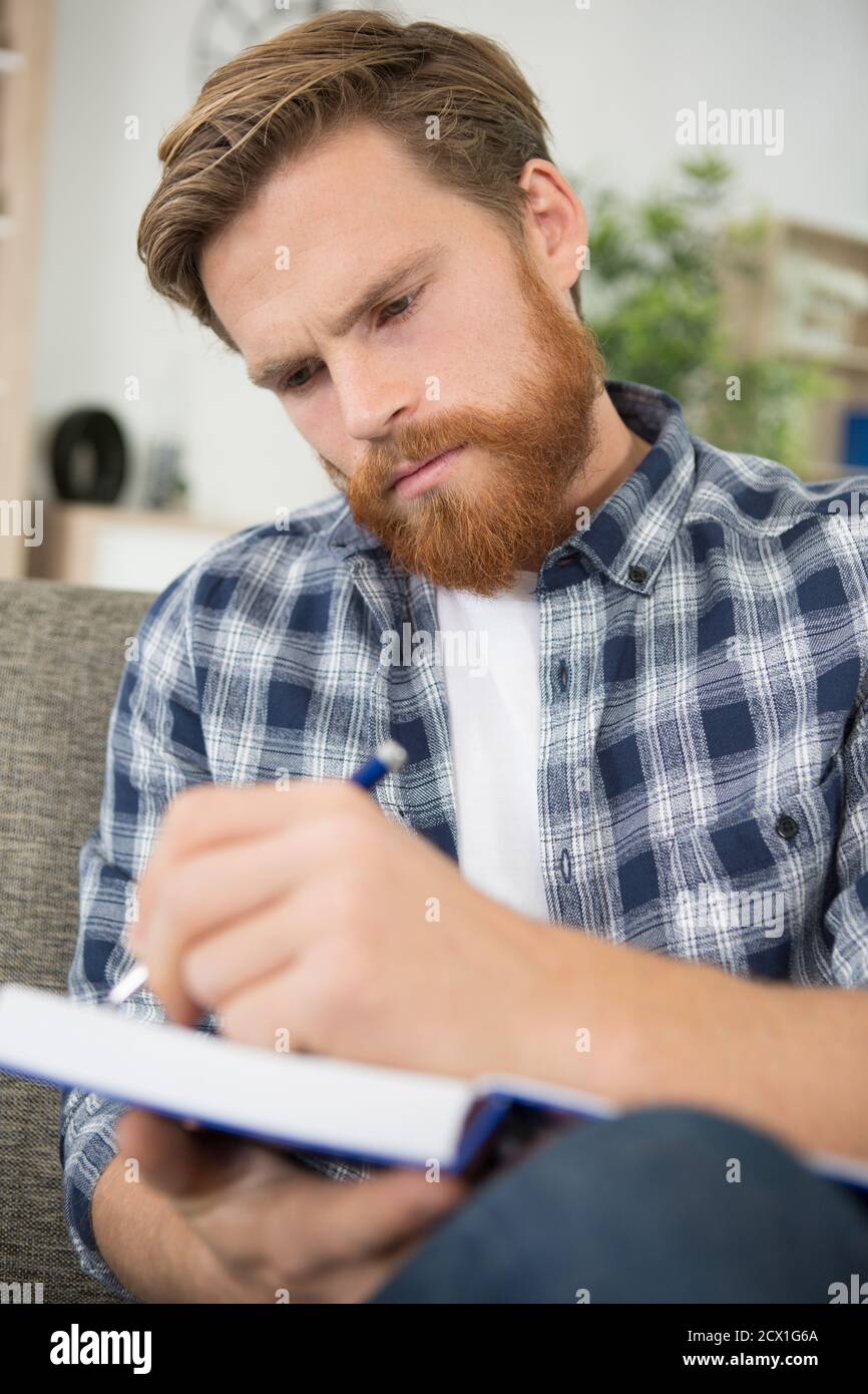 man taking notes in the living room Stock Photo - Alamy