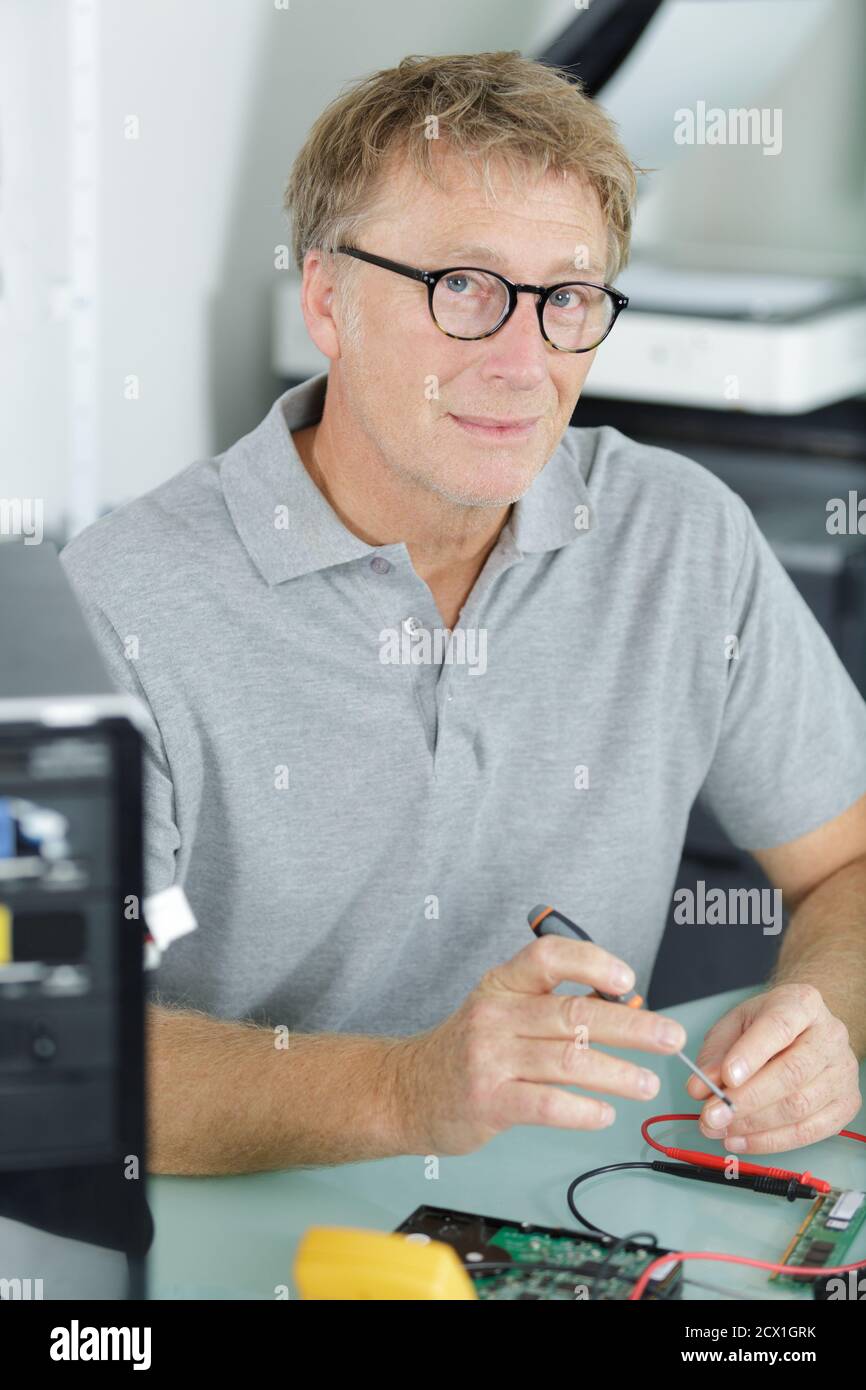 man repairing a computer using a multimeter Stock Photo - Alamy