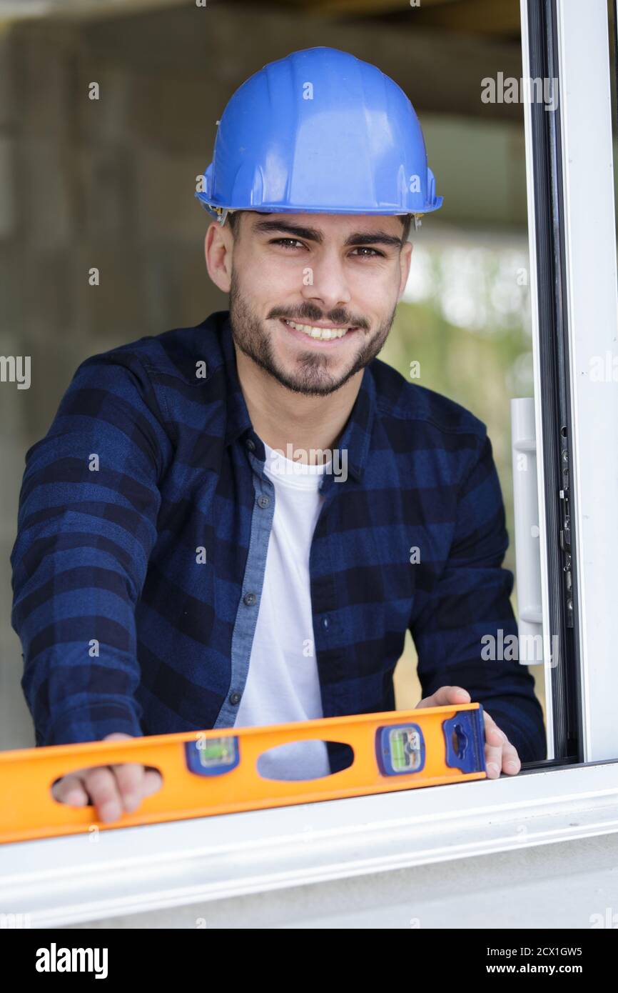 portrait of young builder with spirit level Stock Photo - Alamy