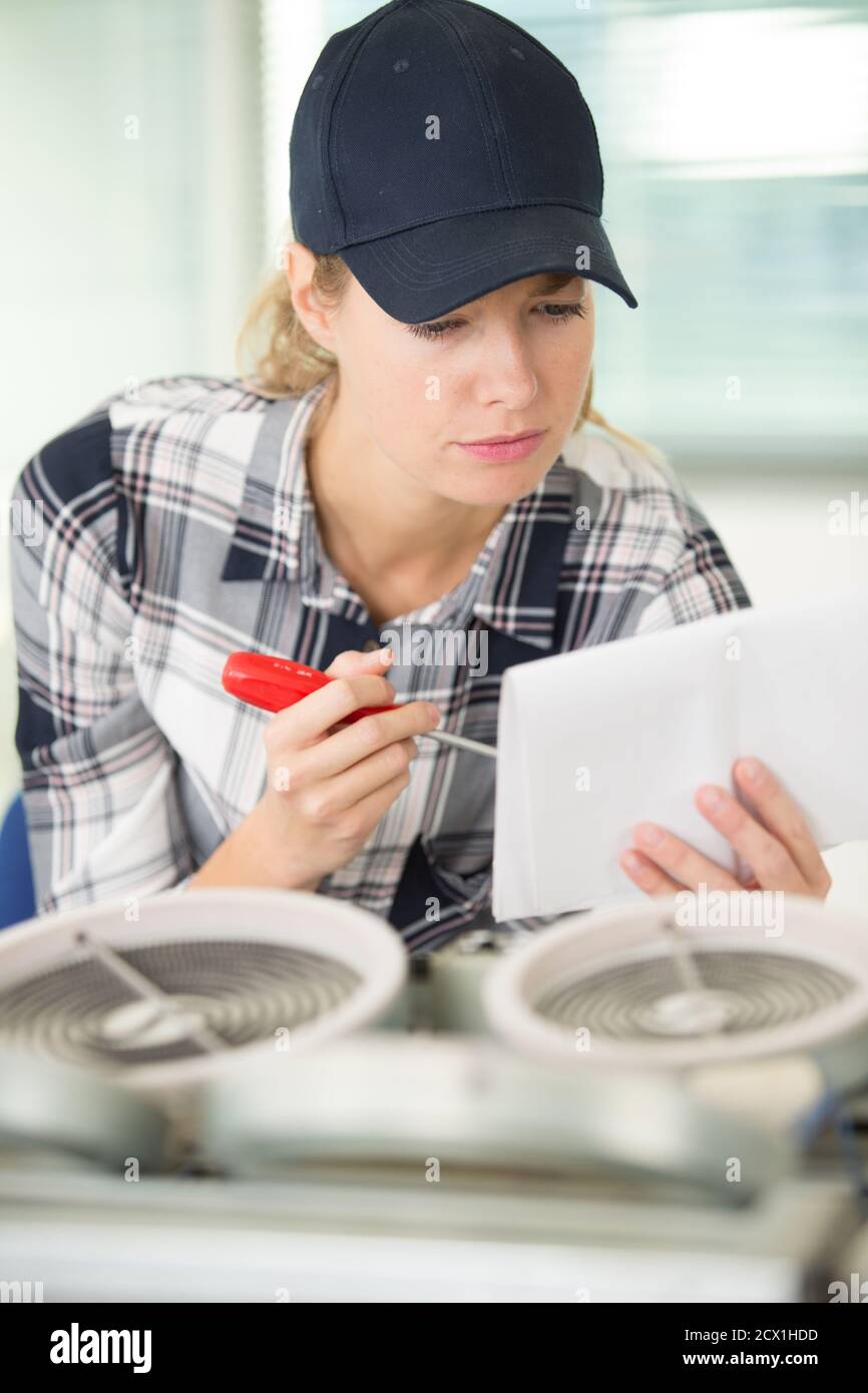 female technician reading instruction manual Stock Photo - Alamy