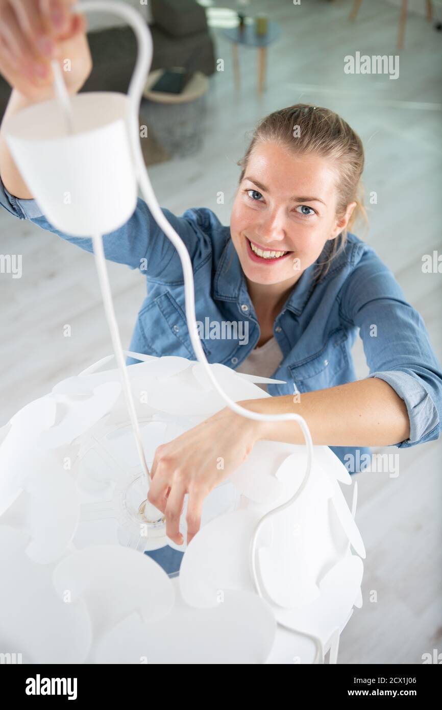 woman in hanging a lamp Stock Photo - Alamy