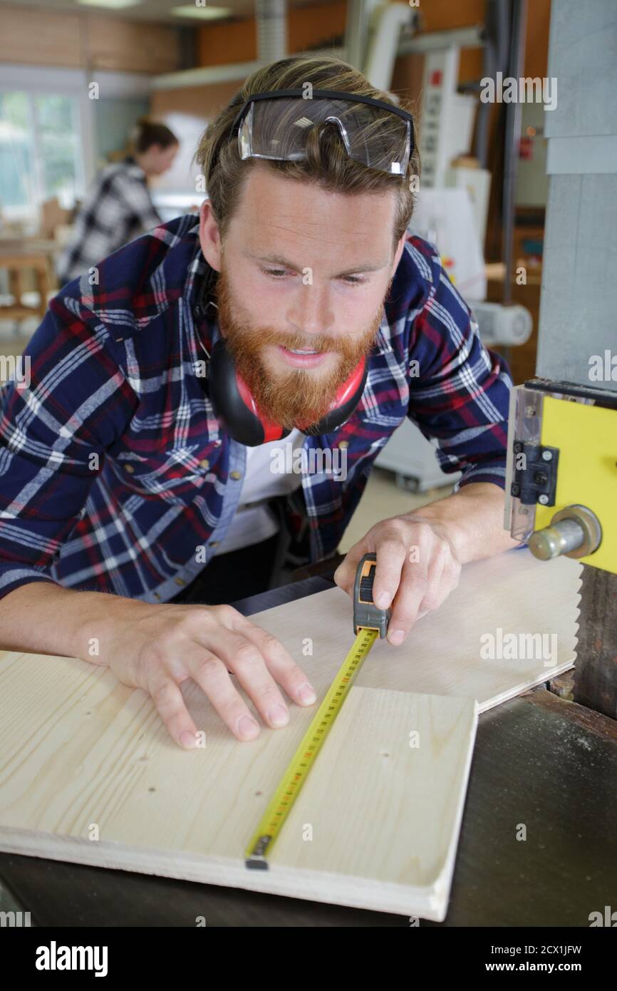 man measuring floor with measure tape in workshop Stock Photo - Alamy