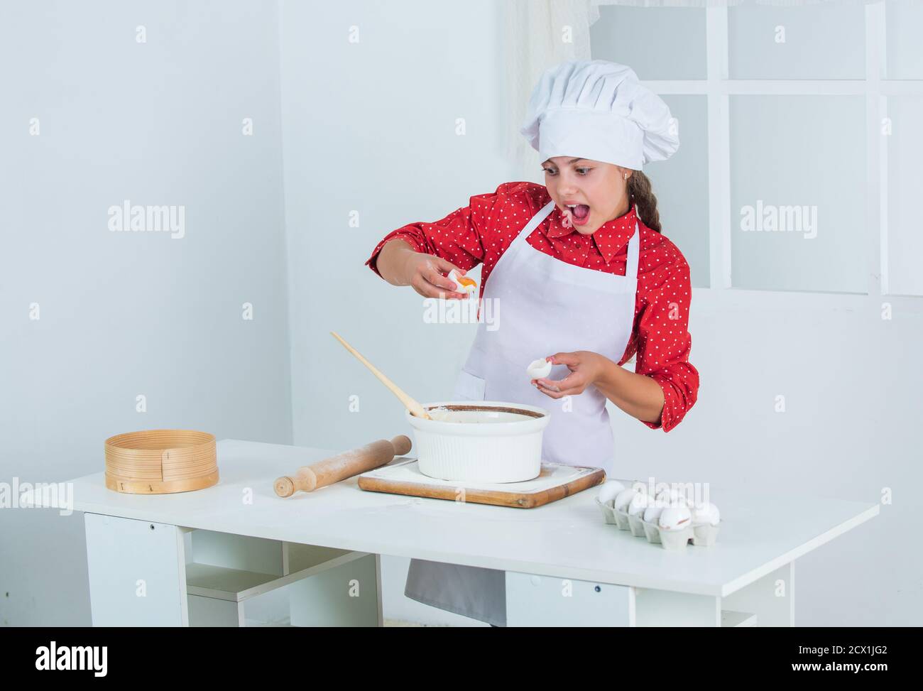 surprised child prepares dough in kitchen, surprise Stock Photo - Alamy