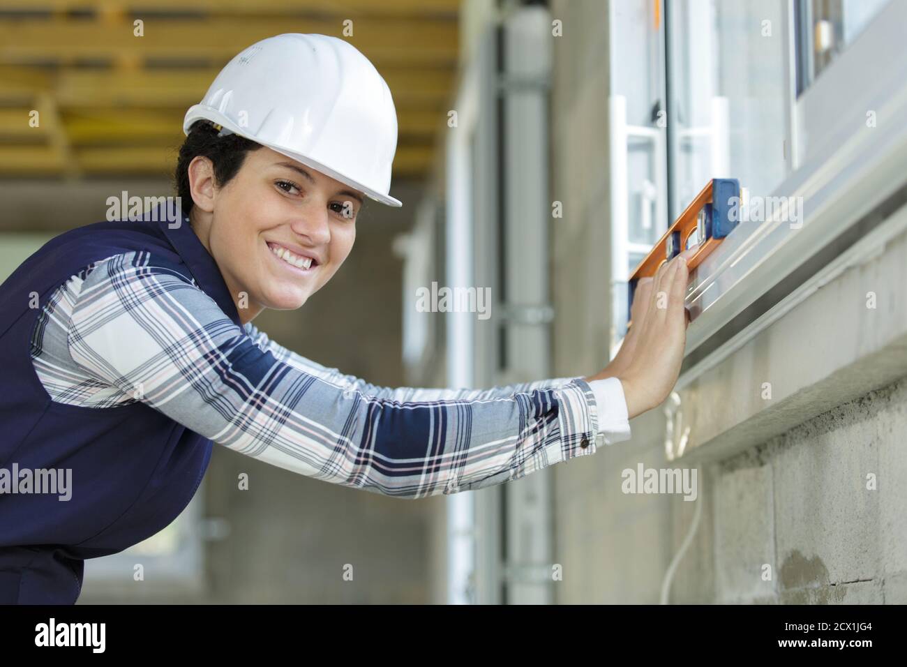 happy woman holding builders level Stock Photo - Alamy