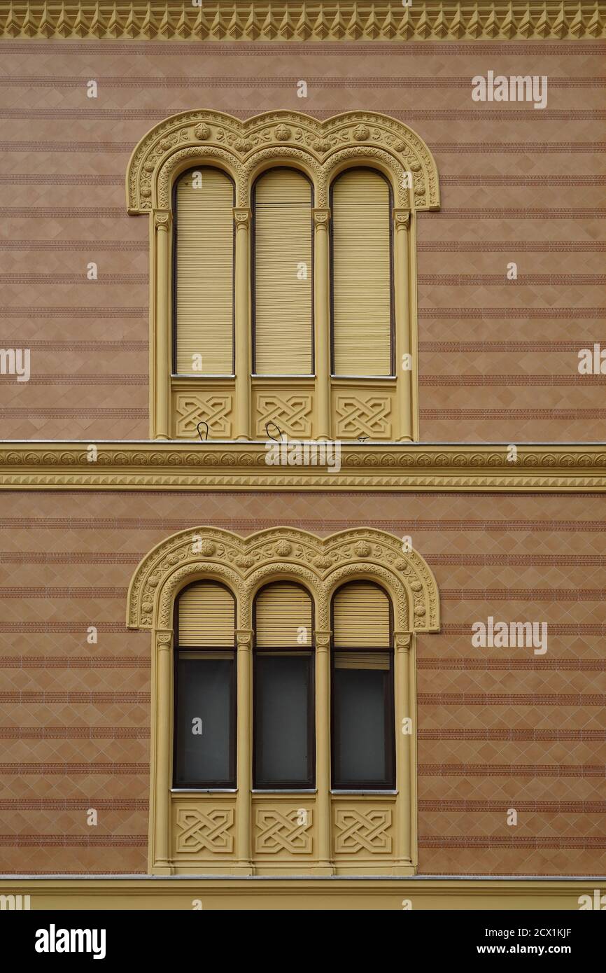 Vertical closeup shot of windows with opened and closed shutters on the ...