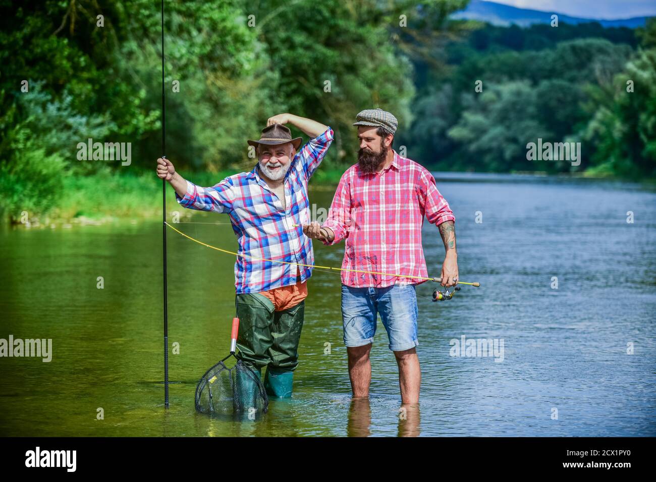 Bound Together In Love. two happy fisherman with fishing rods. summer ...