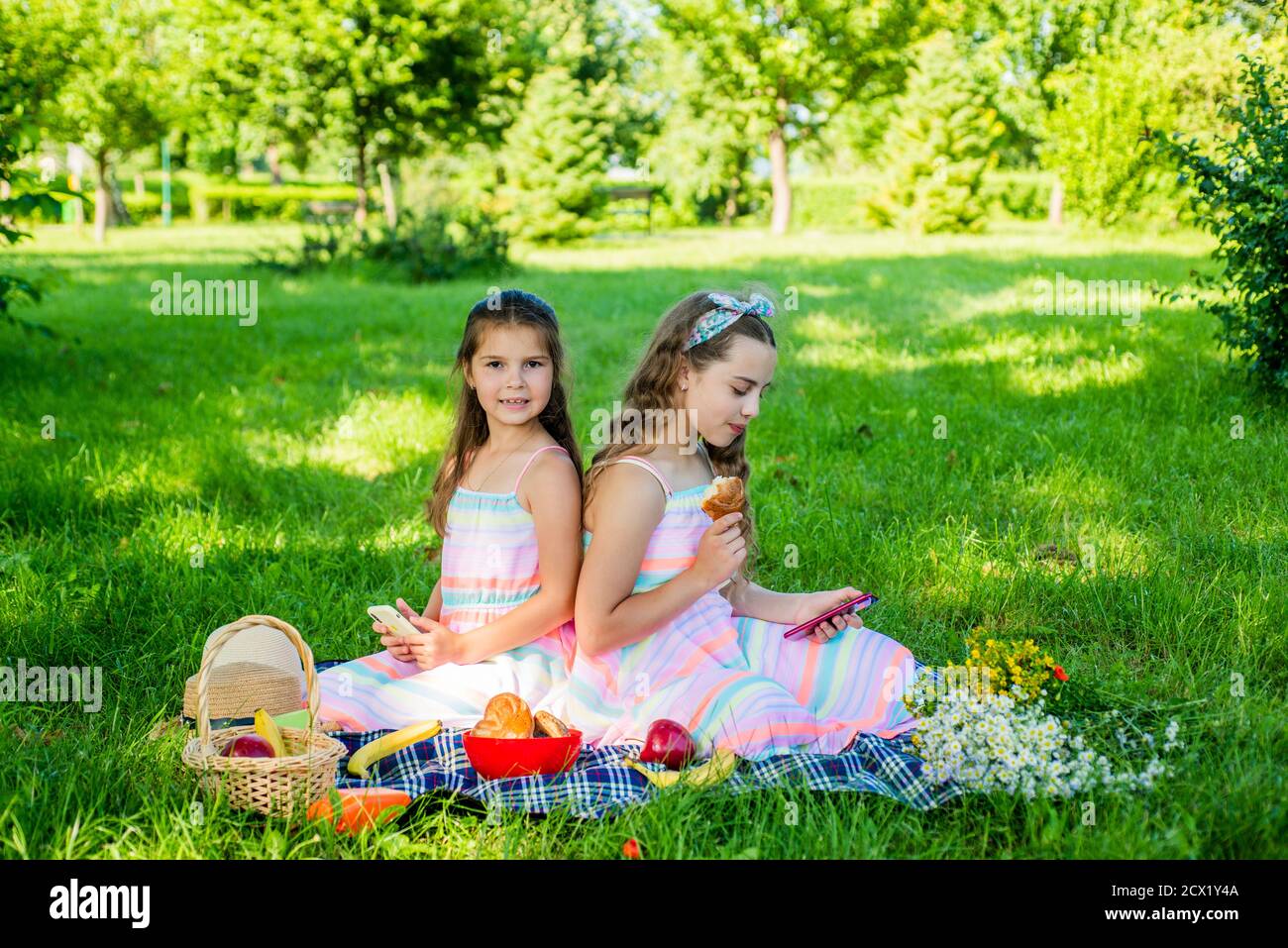 Little girls friends having picnic nature background, idyllic moment ...