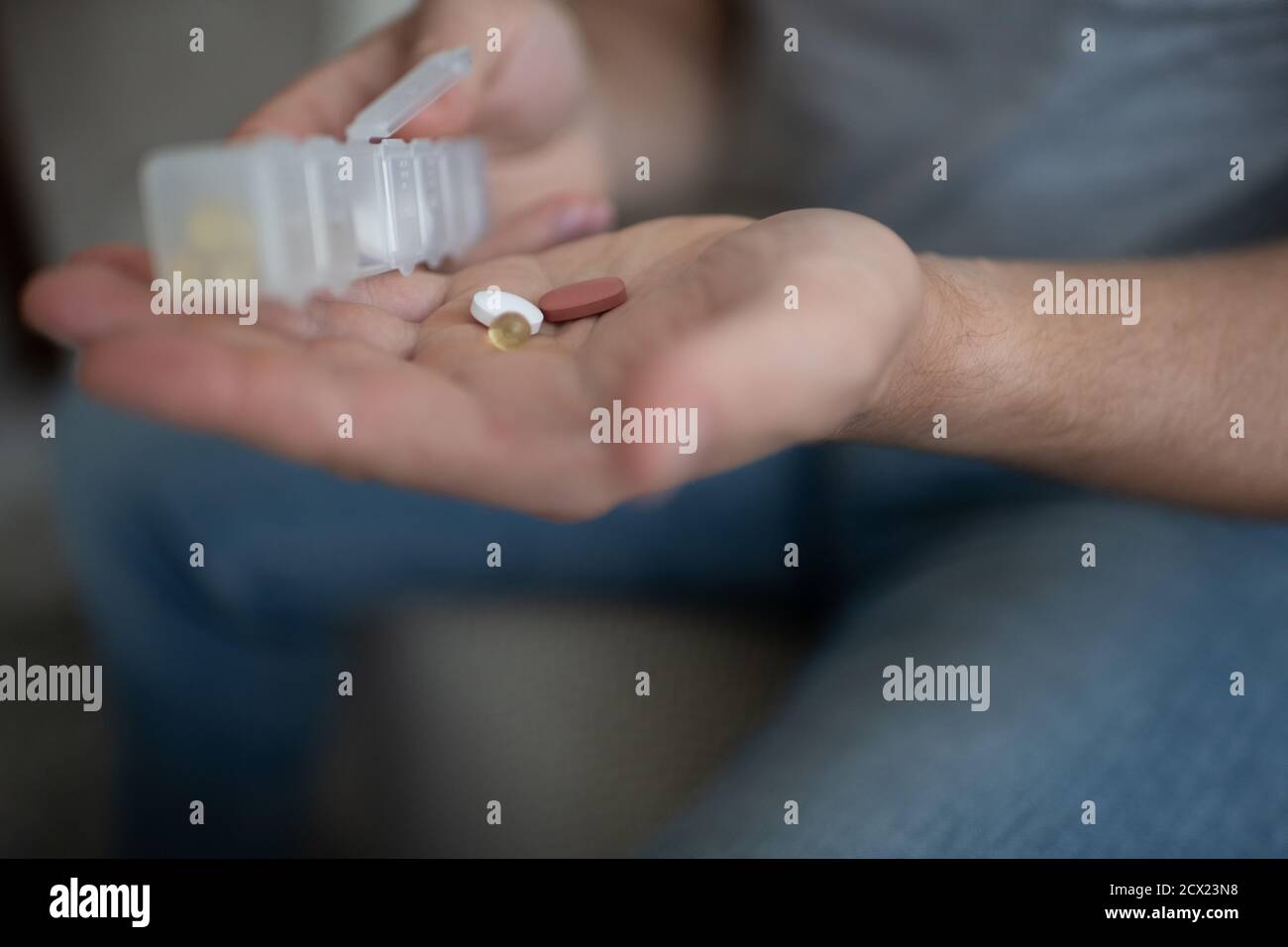 Cropped man taking vitamin tablets from box during health care routine ...