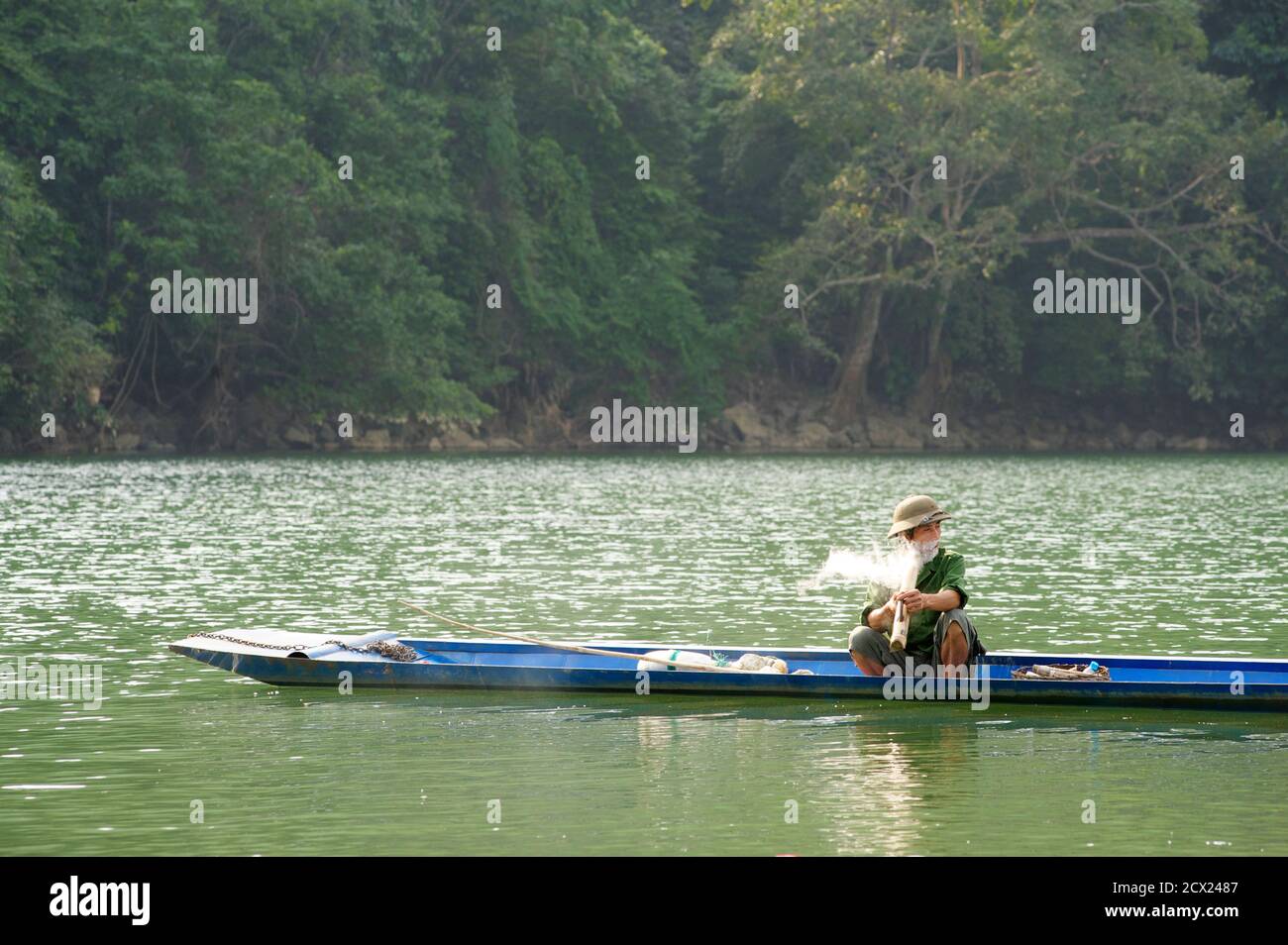 Fisherman smoking a water bong in a boat. Ba Be lake is the largest ...