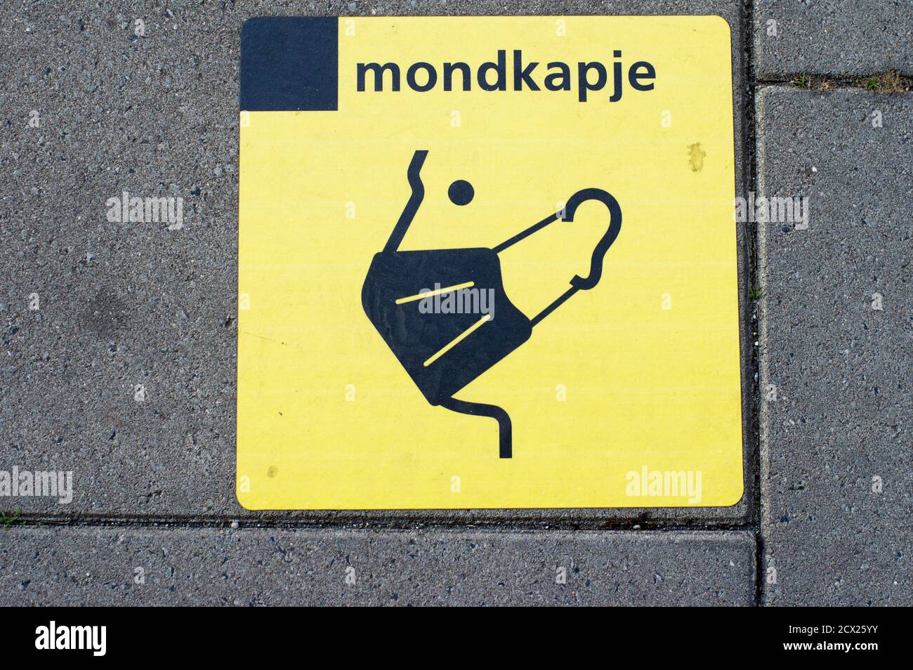 Yellow face mask sign on a tile at an station in the Netherlands ...