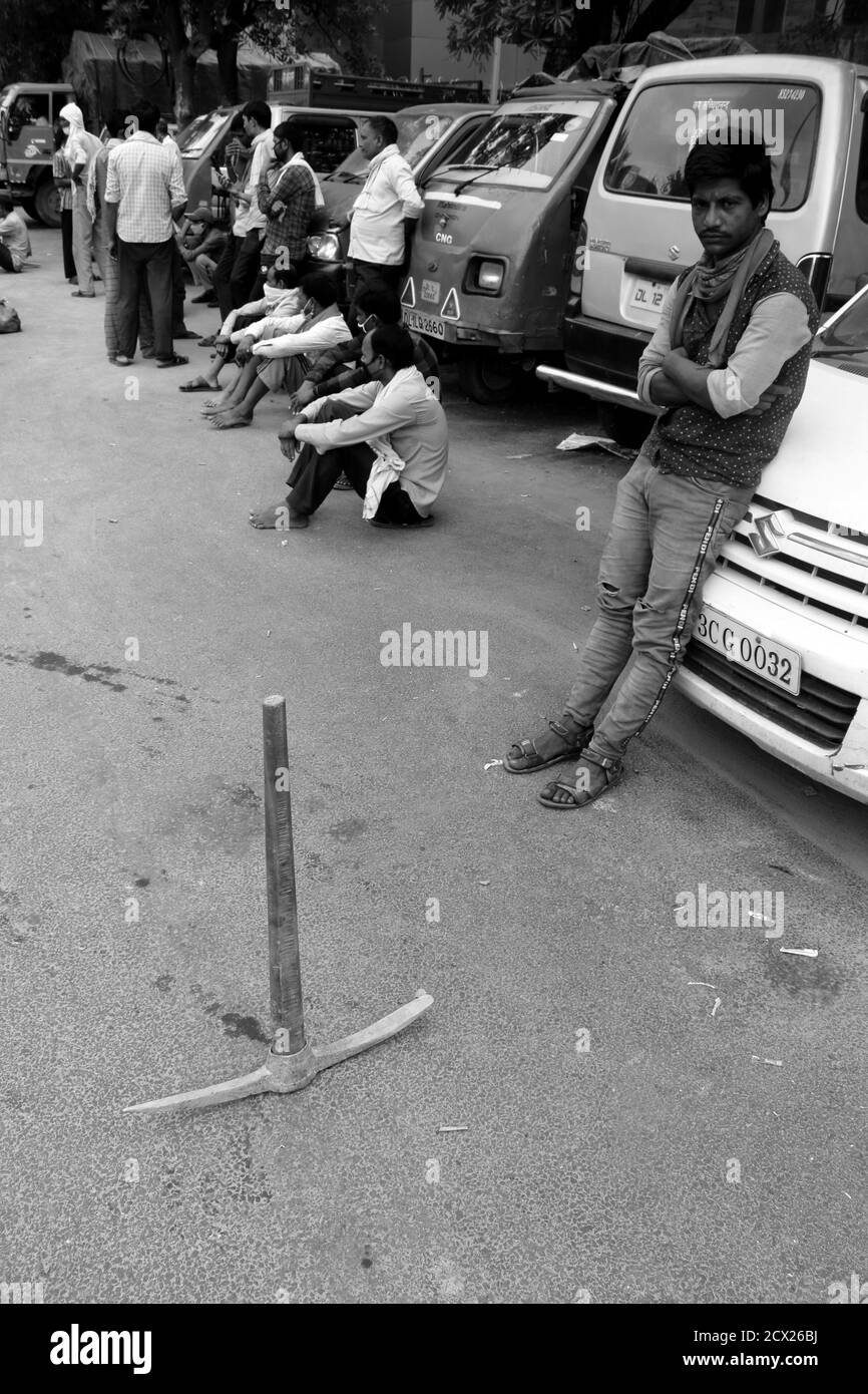 Young Indian construction worker waiting for work, black & white image ...