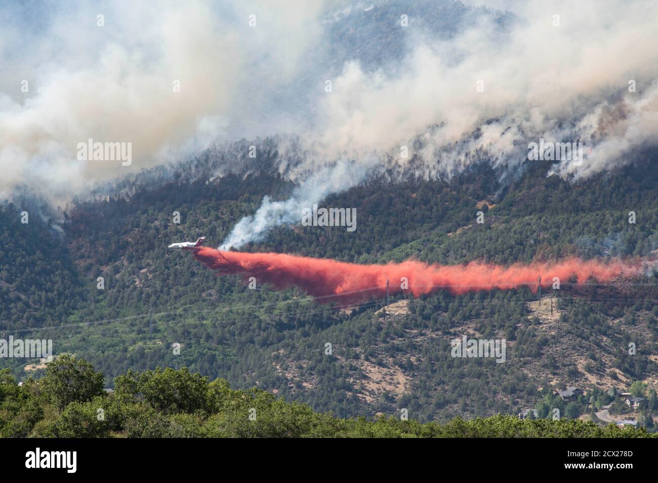 Aircraft discharging fire retardant on wildfire in forest Stock Photo ...