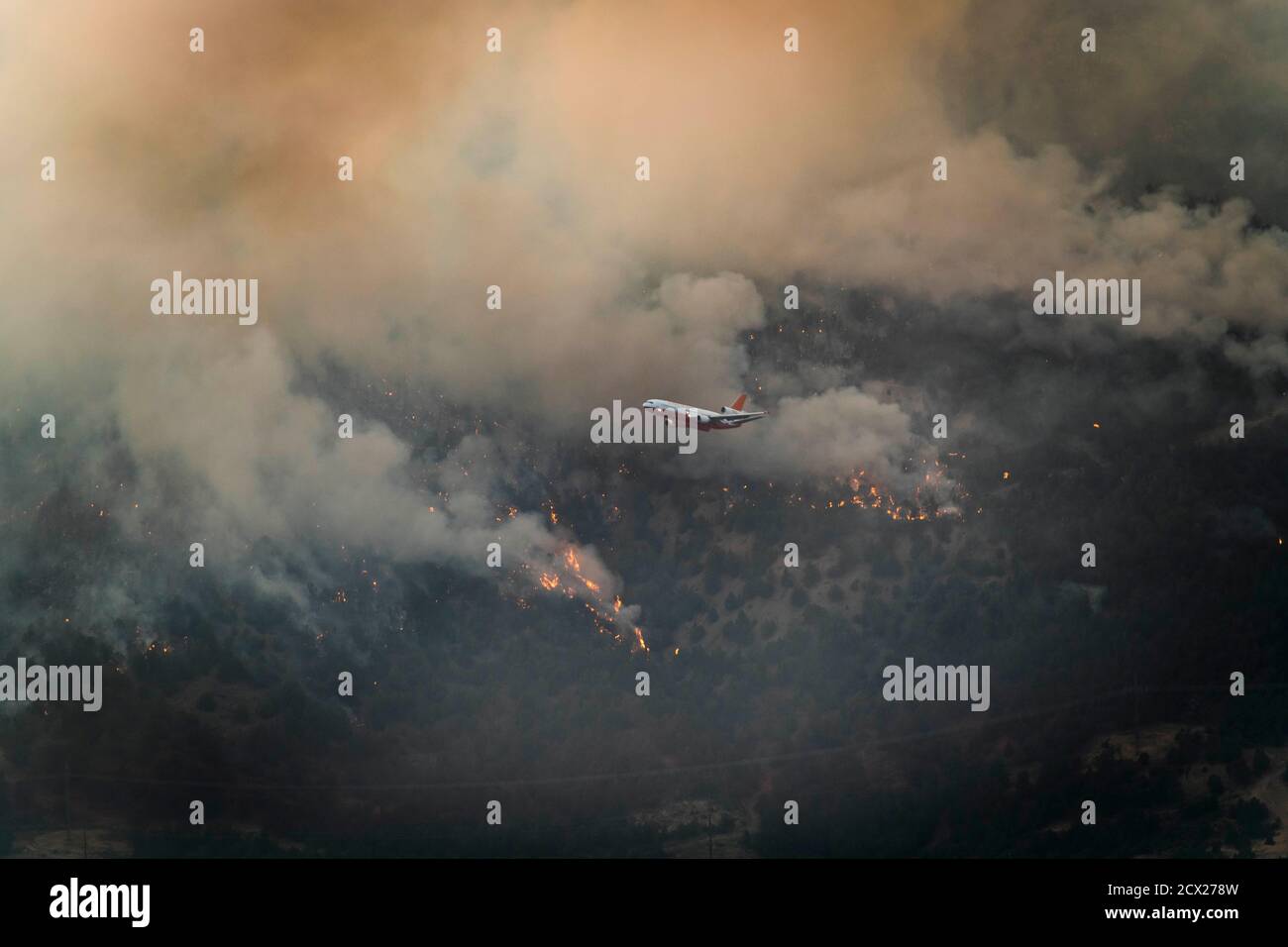Aircraft flying over wildfire in forest Stock Photo - Alamy