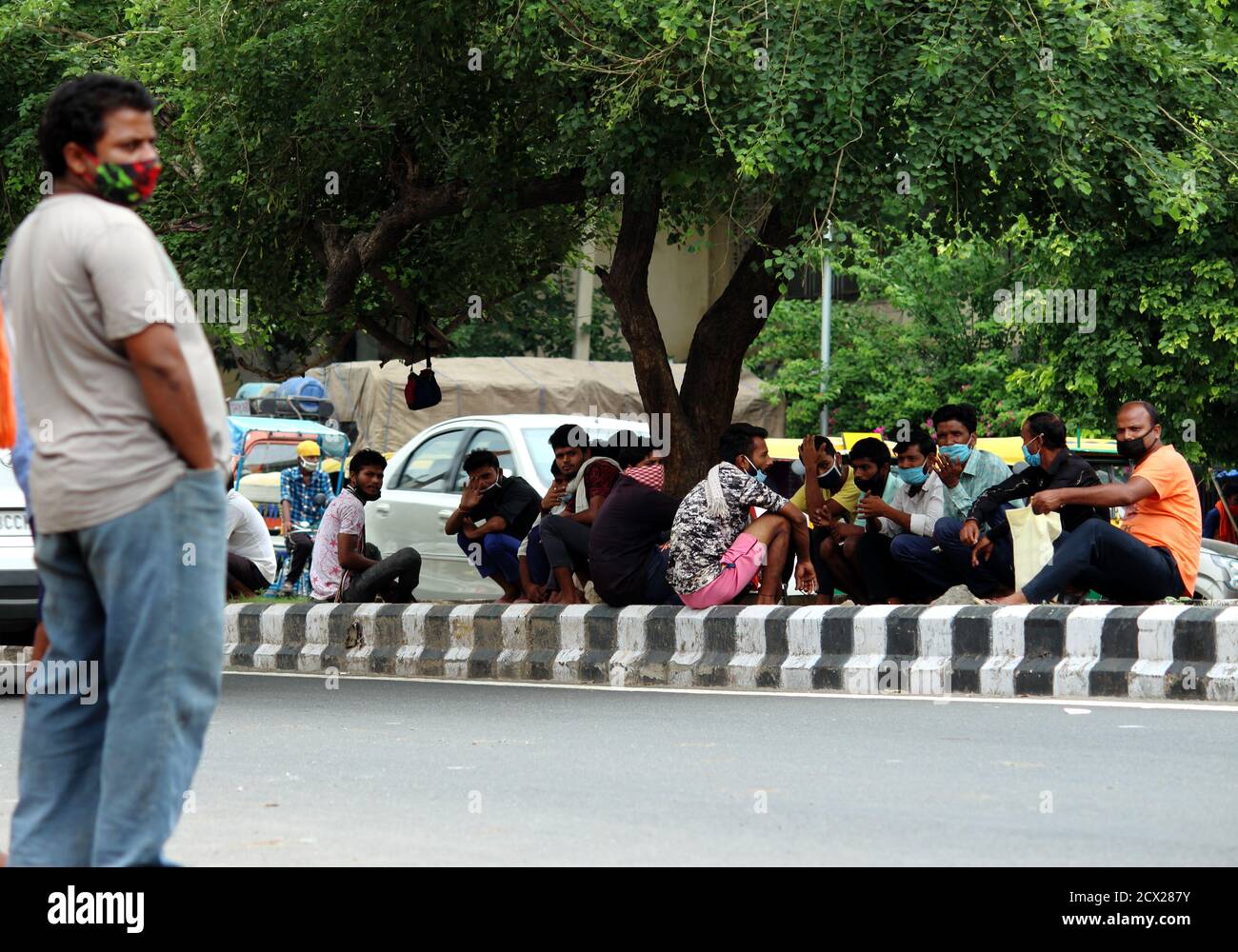 Indian Construction worker sitting on divider waiting for work Stock ...