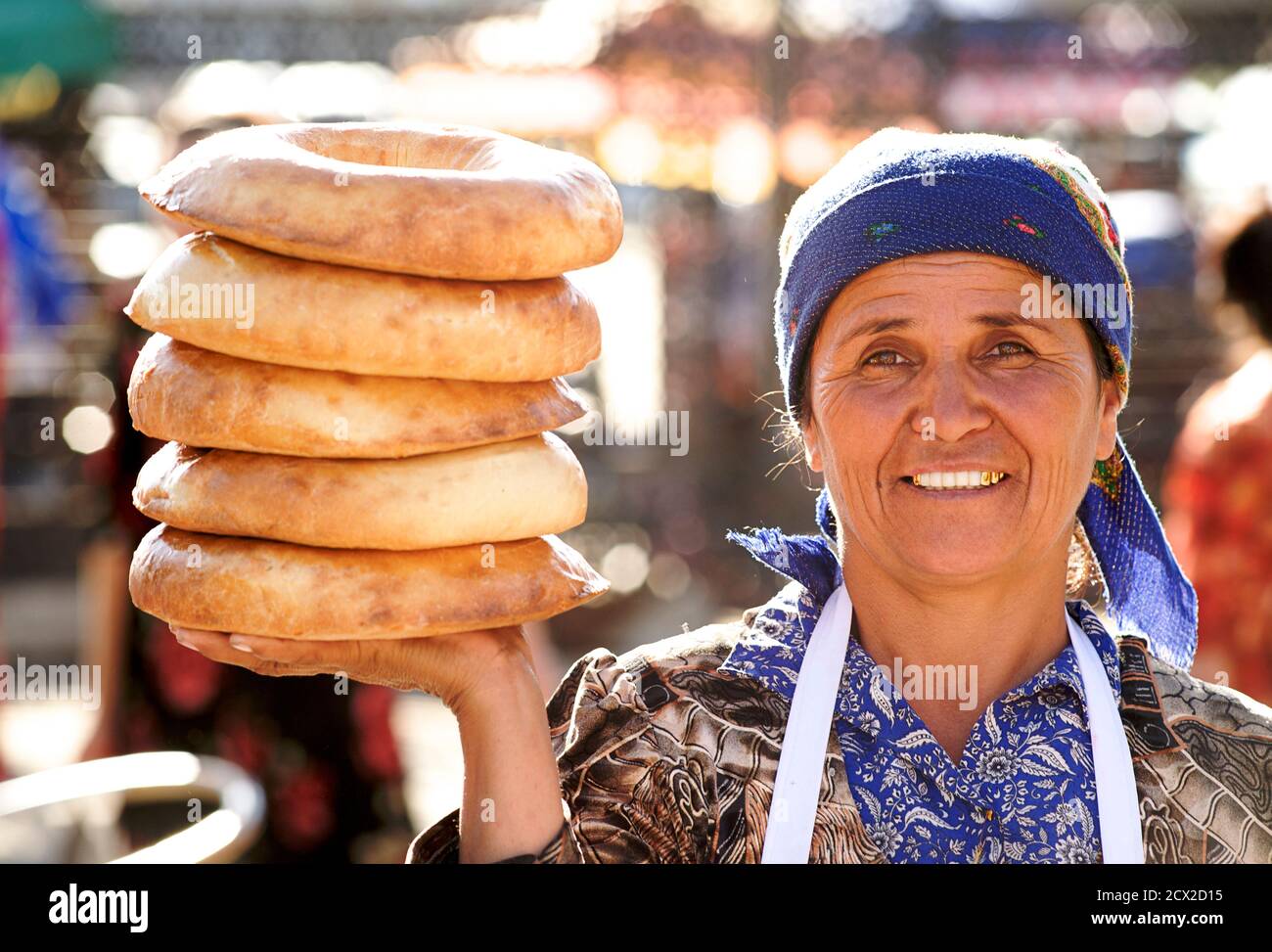 Friendly Uzbeki bread seller with Uzbeki style bread as cooked in a ...