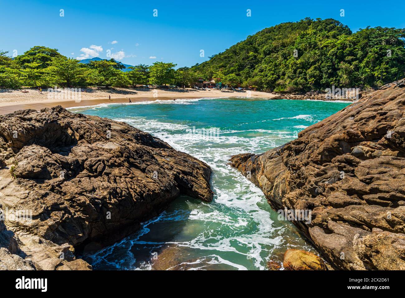 Small beach in a wild tropical landscape viewed from rocks on the shore ...