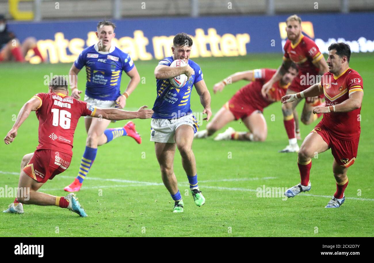 Leeds Rhinos' Liam Tindall (centre) makes a break past Catalans Dragons ...