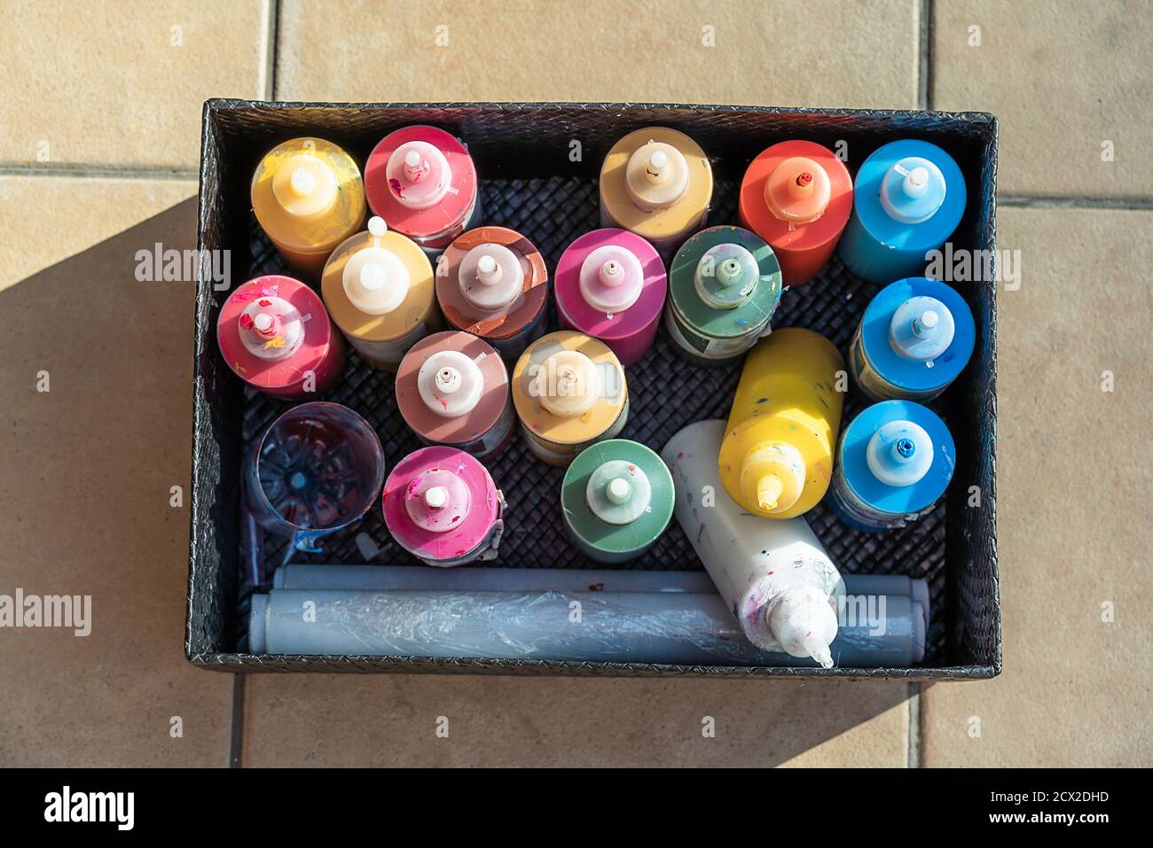 many painting pots in several color in a black box on the floor ...