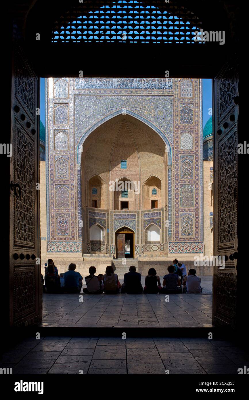 The Mir-i-arab Madrassah seen through the doors of the Kalon Mosque, Bukhara, Uzbekistan ...