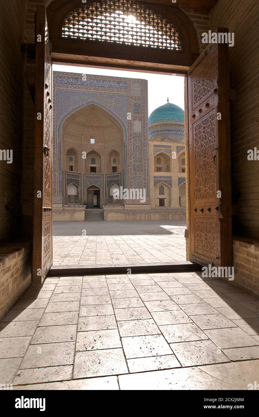 The Mir-i-arab Madrassah seen through the doors of the Kalon Mosque, Bukhara, Uzbekistan Stock ...