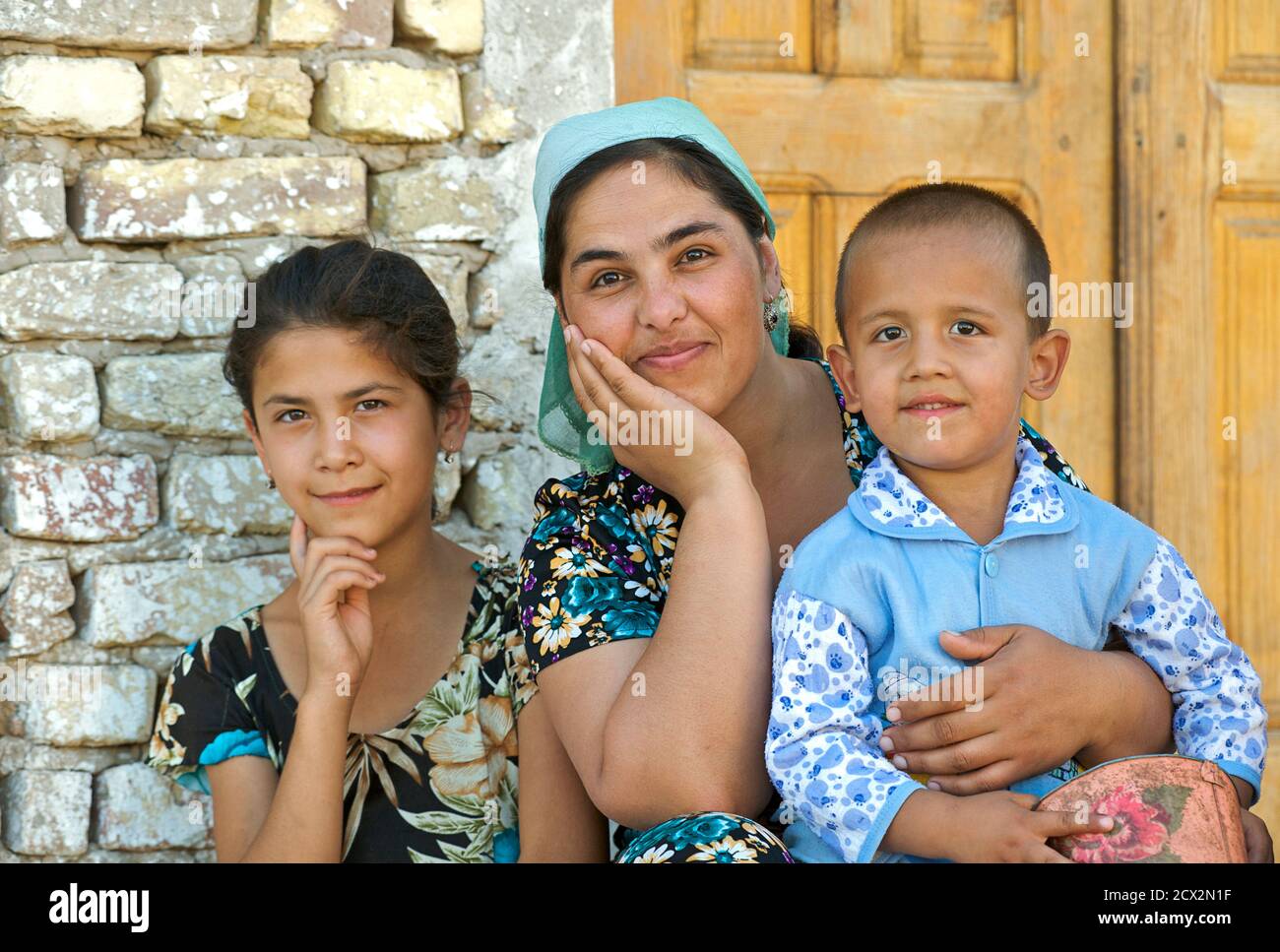 Portrait of a smiling Uzbeki woman in Uzbeki attire with children ...