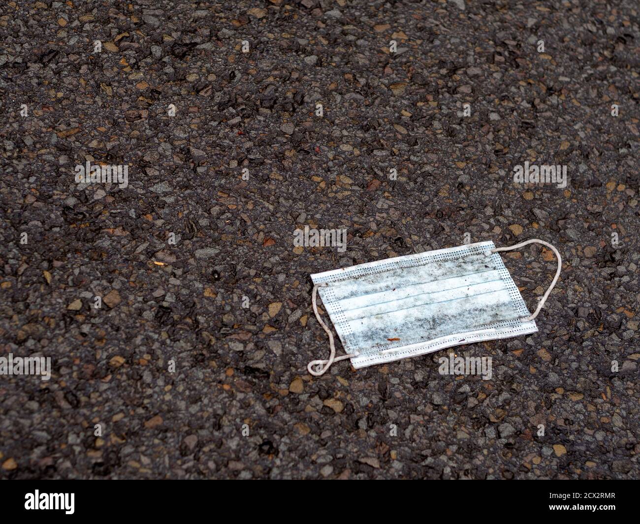 Dirty medical face mask discarding leave carelessly on the walkway by ...