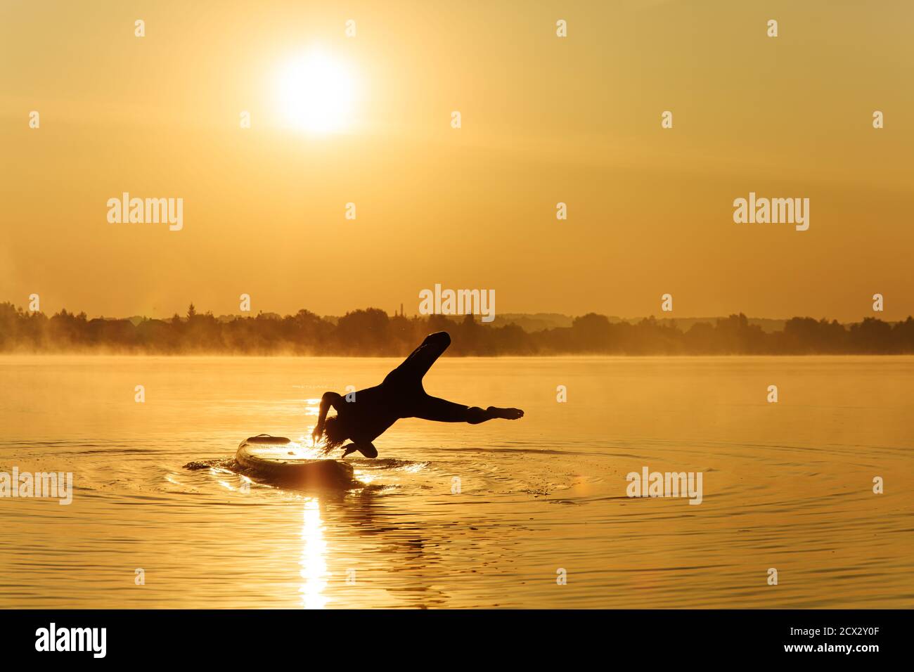 Sporty man lost balance on board and falling down into lake Stock Photo ...