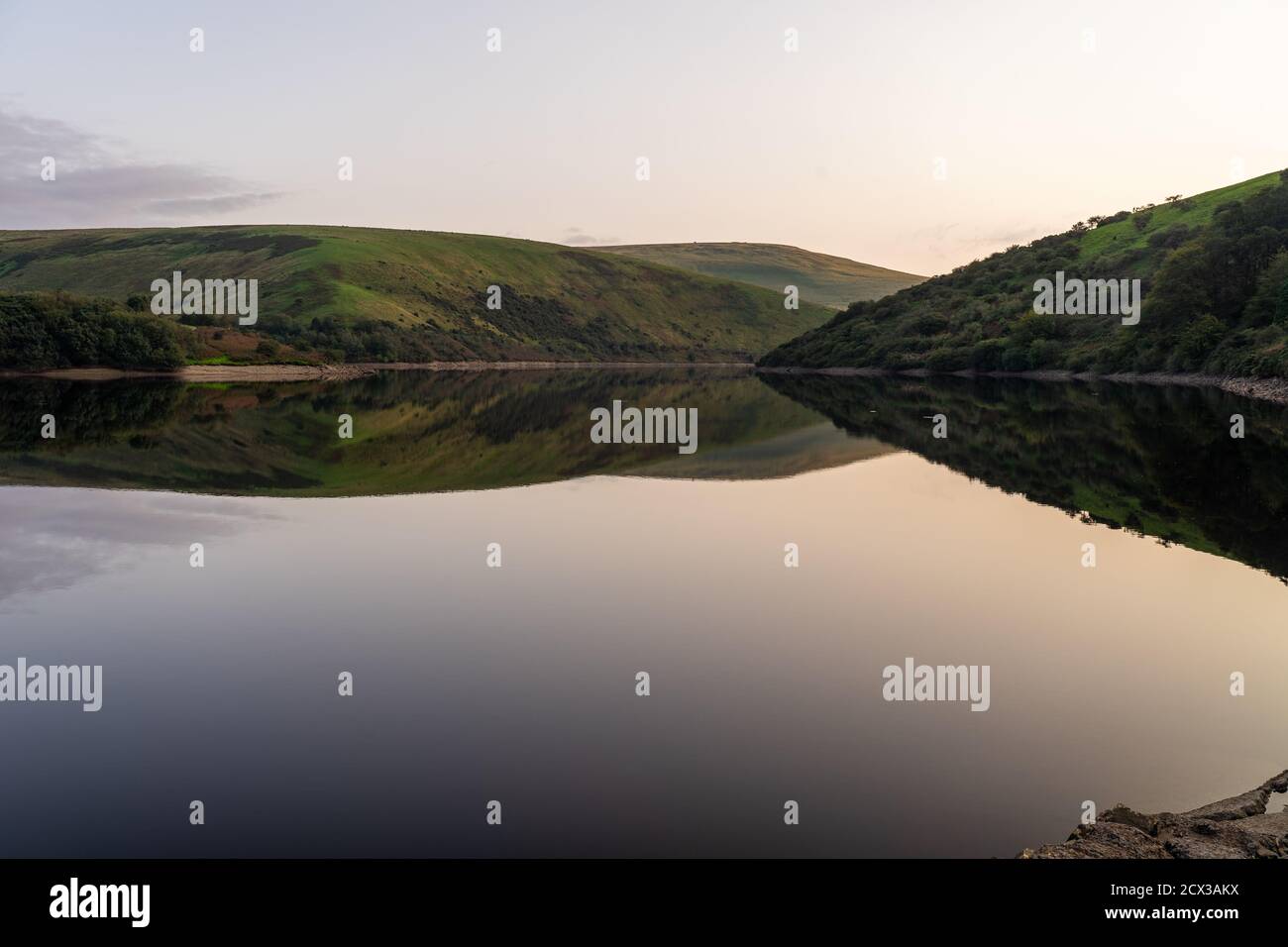 Overlapping hills reflected in still water at dusk Stock Photo - Alamy