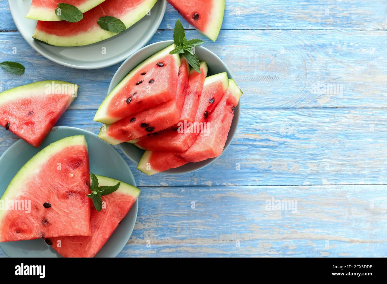 Flat lay fresh red watermelon slices on an blue rustic wood background ...