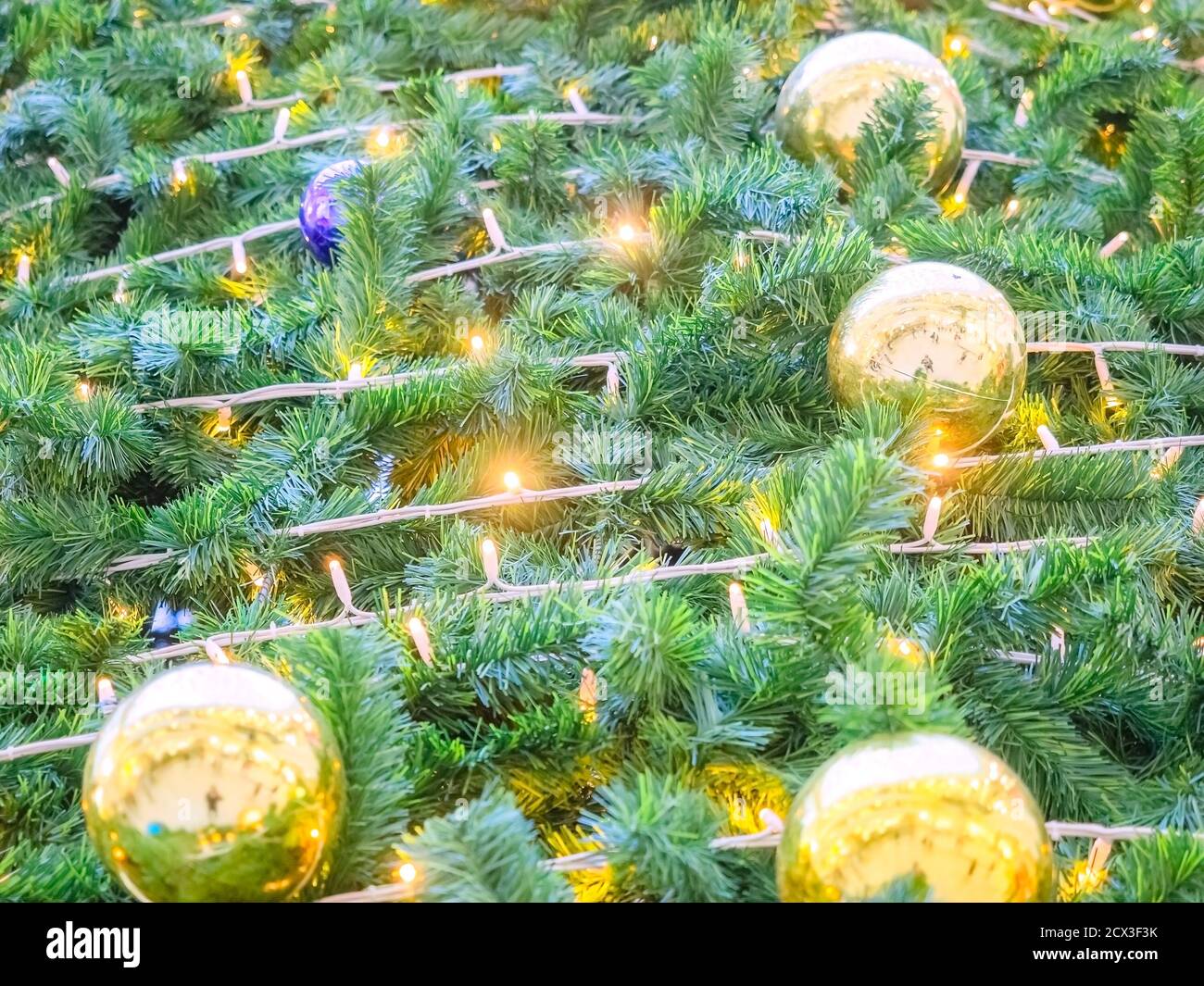 Lush Christmas tree with glowing garland, blue and golden balls. Full ...