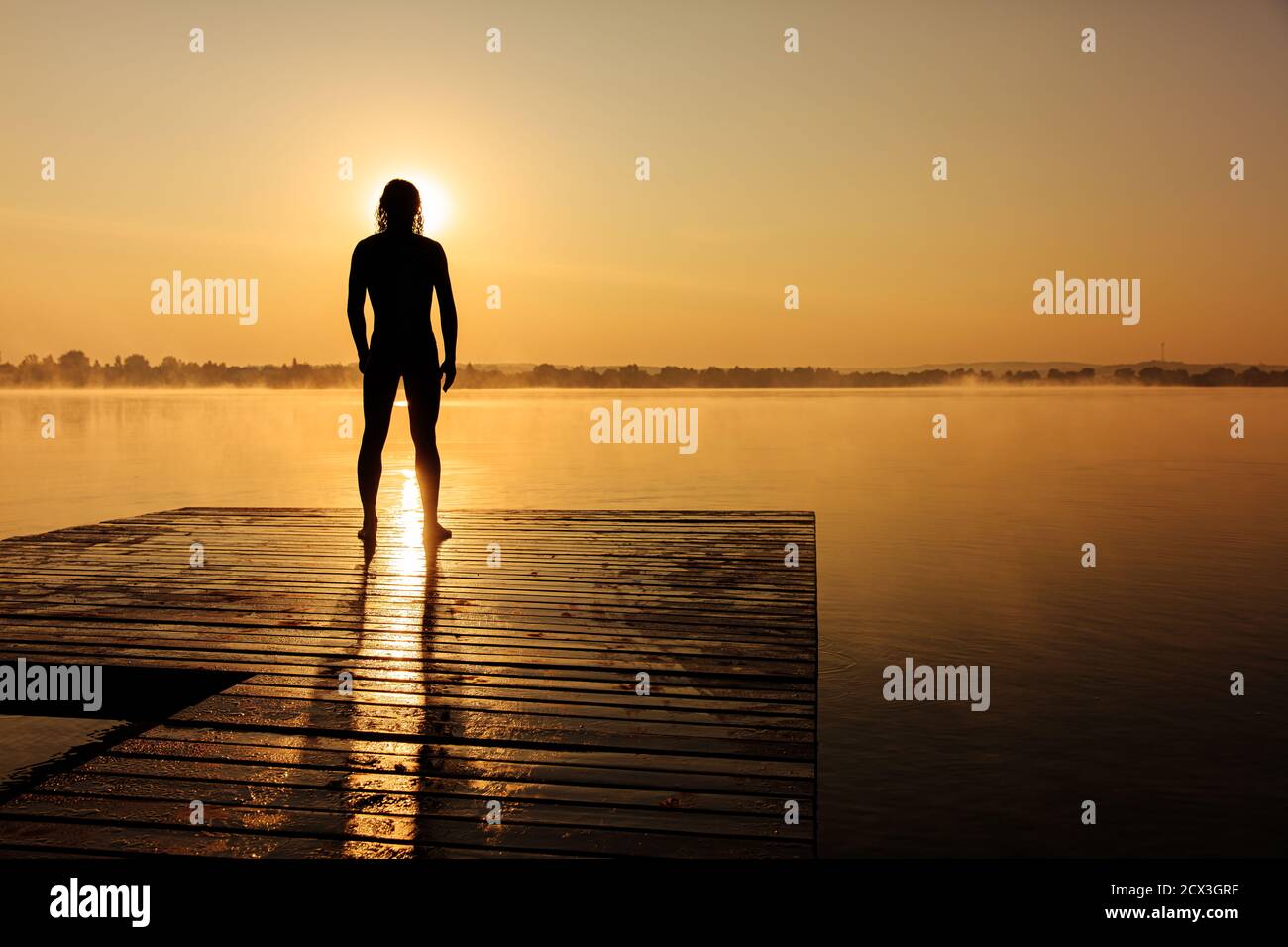 Boy standing on pier by lake hi-res stock photography and images - Alamy