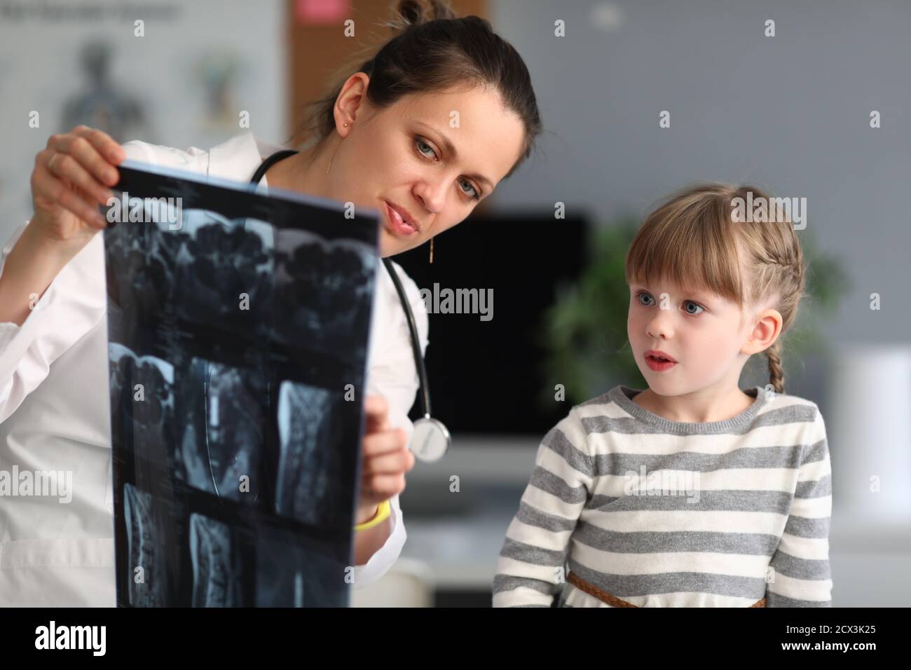 Woman doctor shows child patient an xray in clinic Stock Photo - Alamy