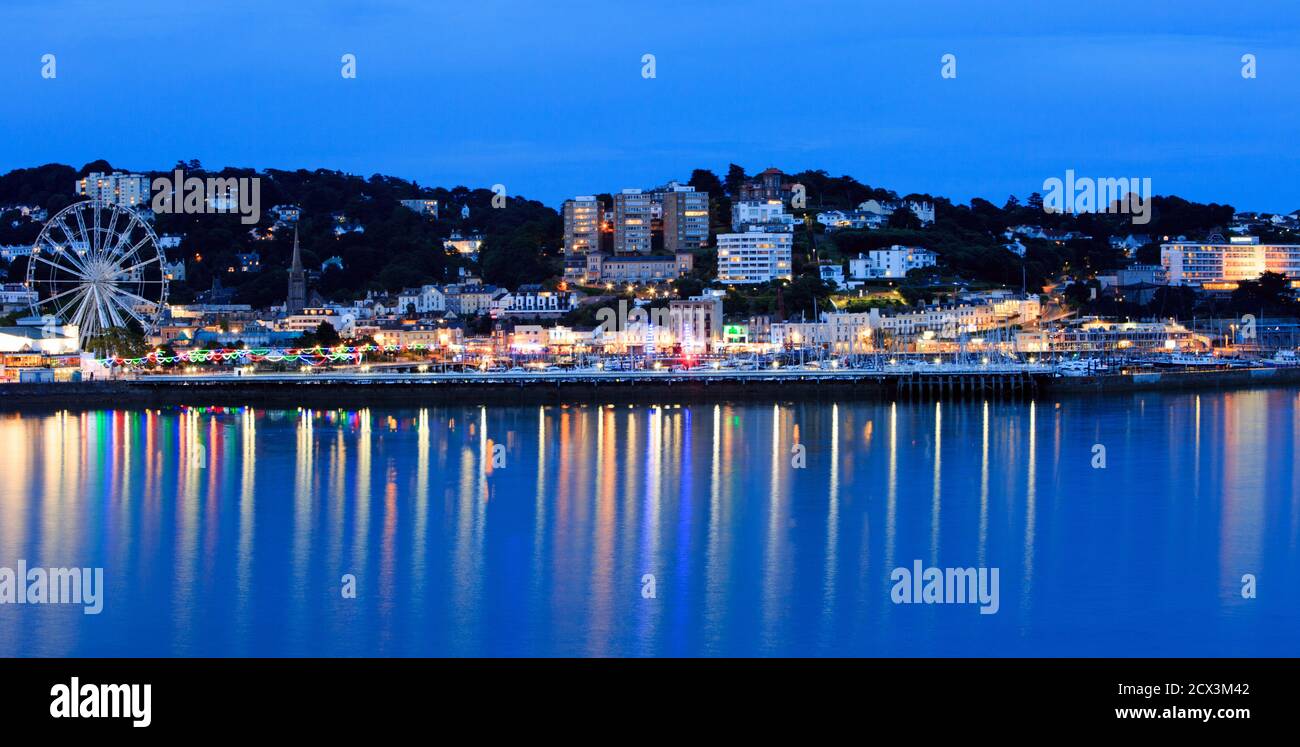 Torquay Promenade at dusk with illuminated lights reflecting in the sea ...