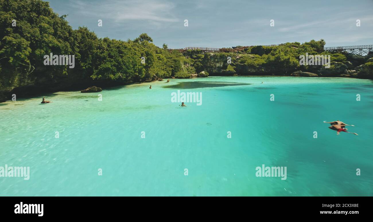 Closeup aerial view of limpid lake on green cliff ocean shore ...