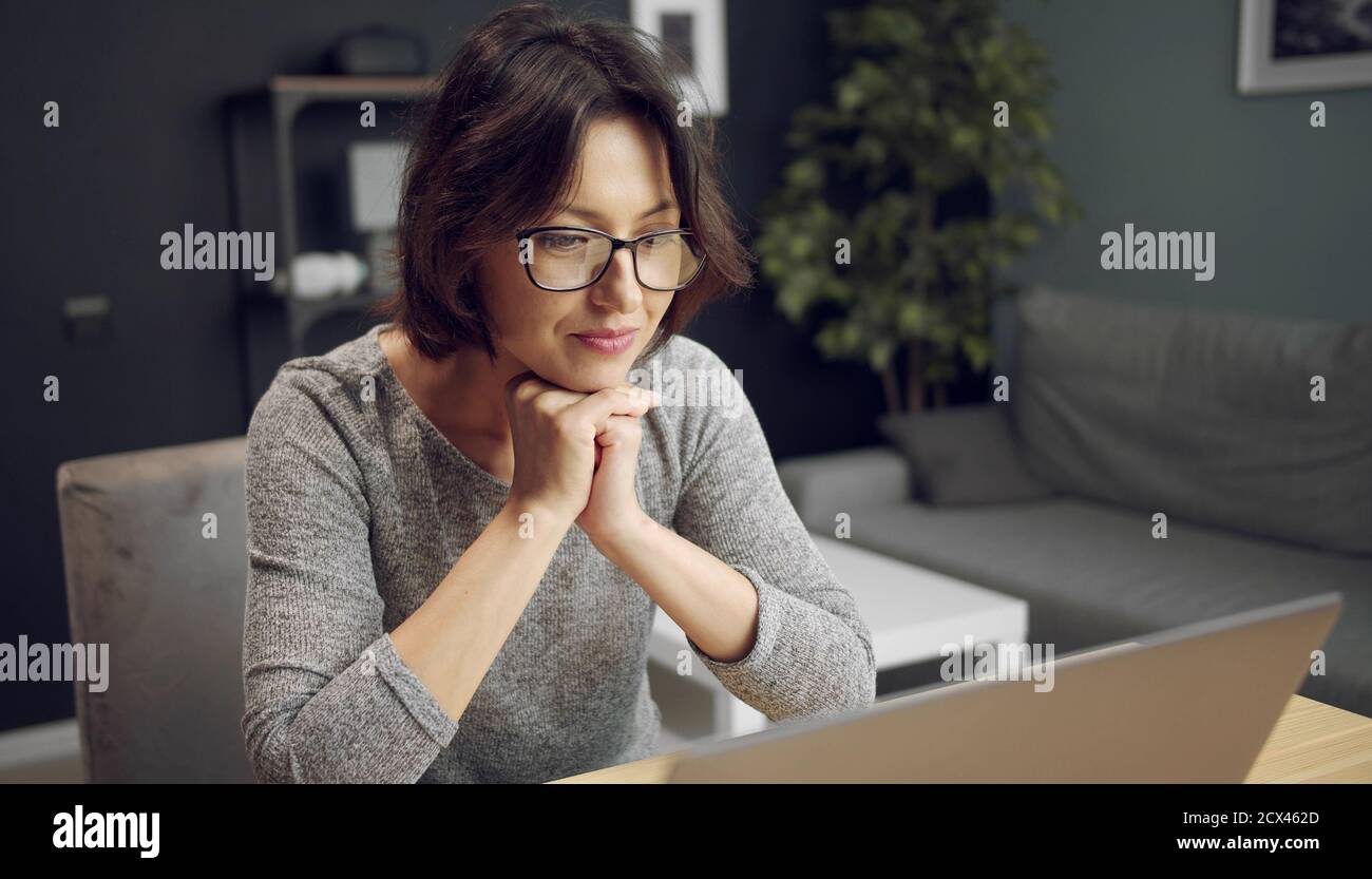 Woman looking at laptop screen Stock Photo - Alamy