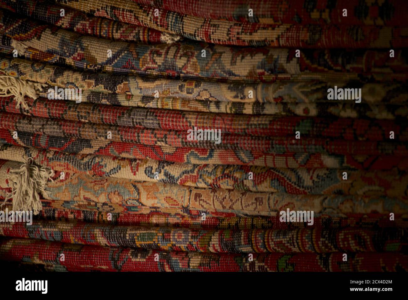 Folded Persian carpets in a stack for sale at market, Isfahan, Iran ...