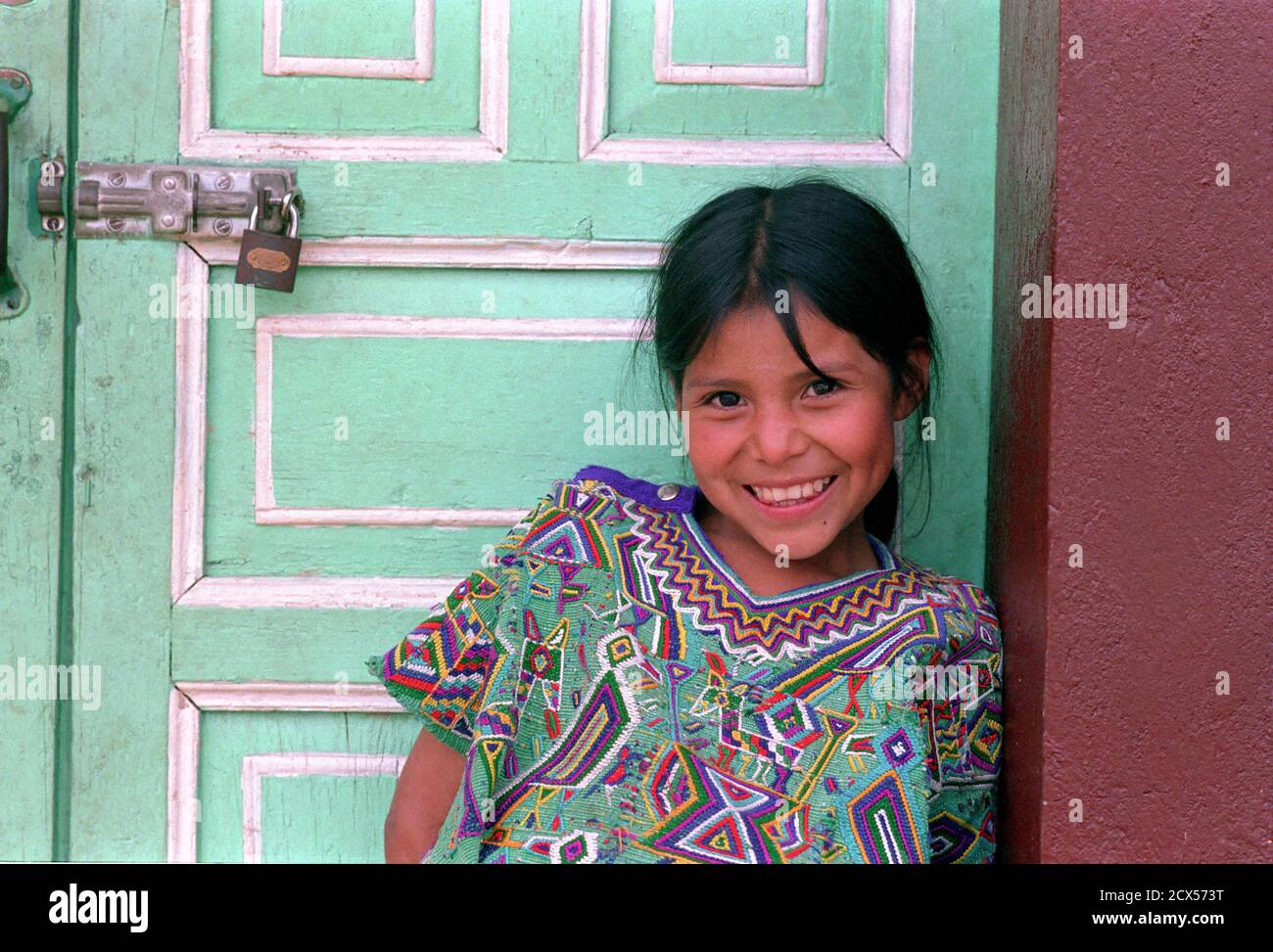 Ixil Maya girl outside the brightly painted doors of the local radio ...
