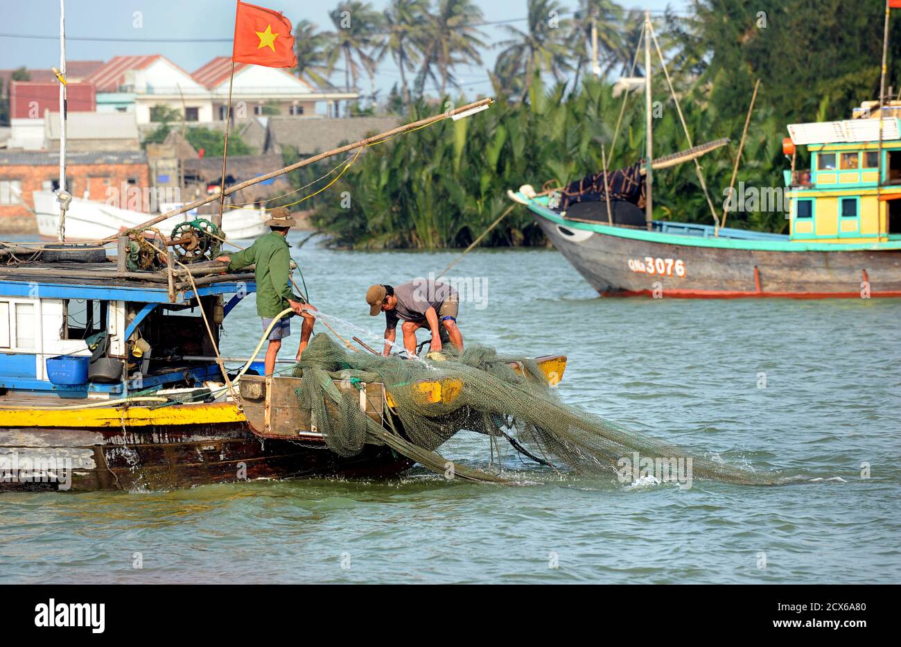 Vietnamese men washing down their fishing nets. Hoi An, Vietnam Stock ...